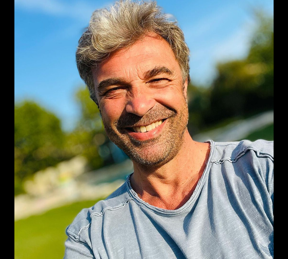 Photo : Jean-Pierre Michaël souriant sur le tournage d'"Ici tout ...