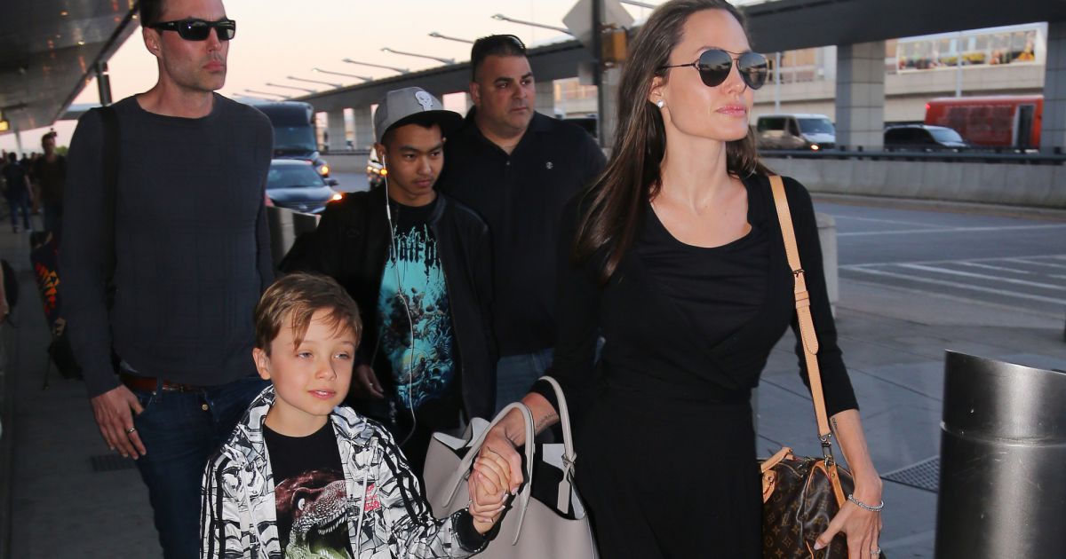 Angelina Jolie tenant la main de son fils Knox, son aîné Maddox les ...